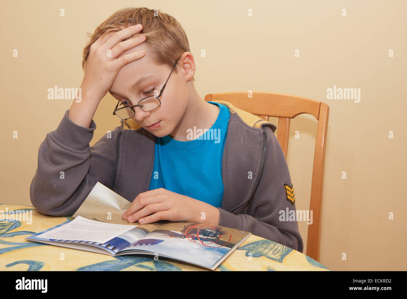 A boy is doing his homework sitting at the table Stock Photo - Alamy