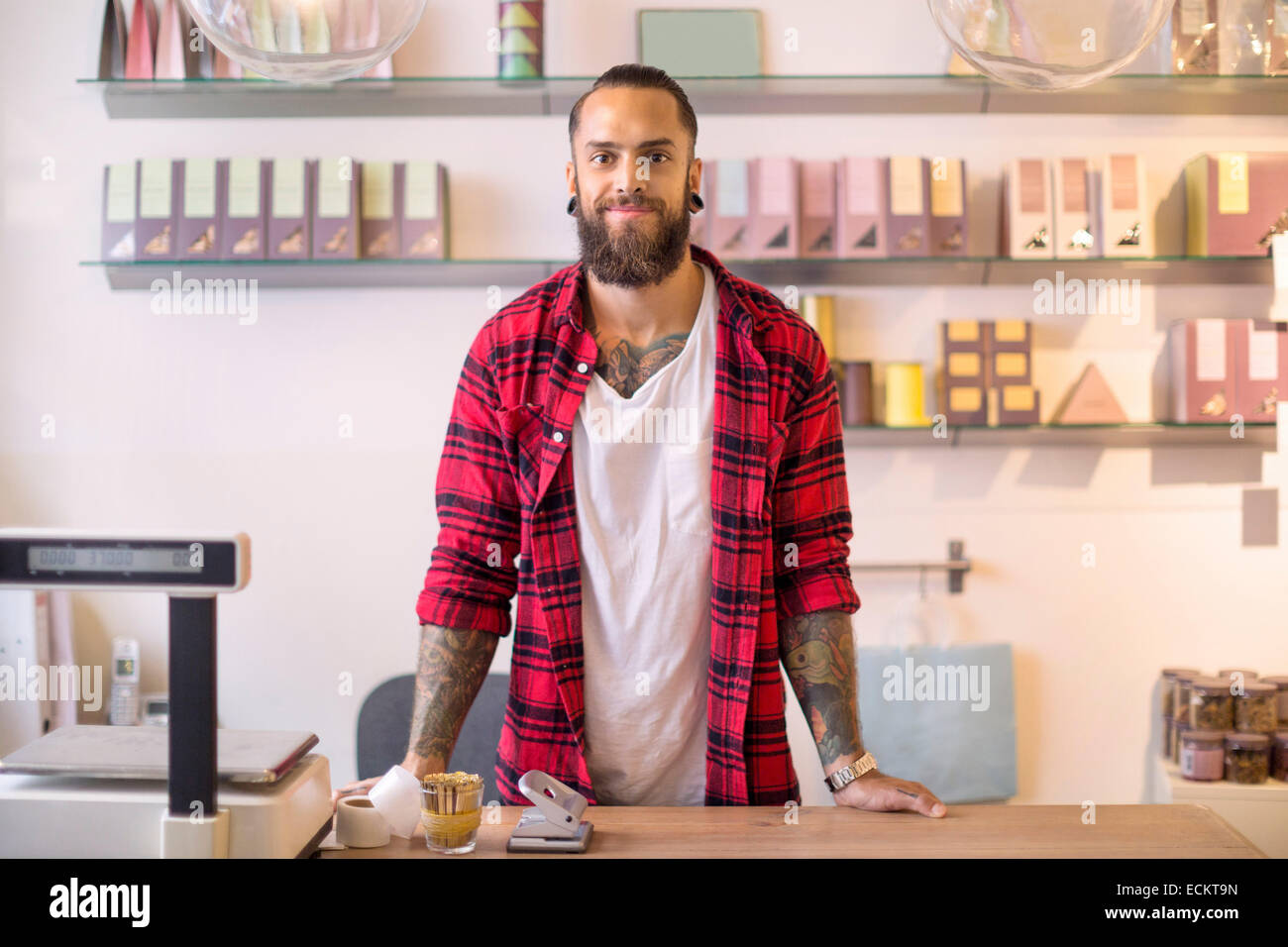 Portrait of smiling owner in candy store Stock Photo - Alamy