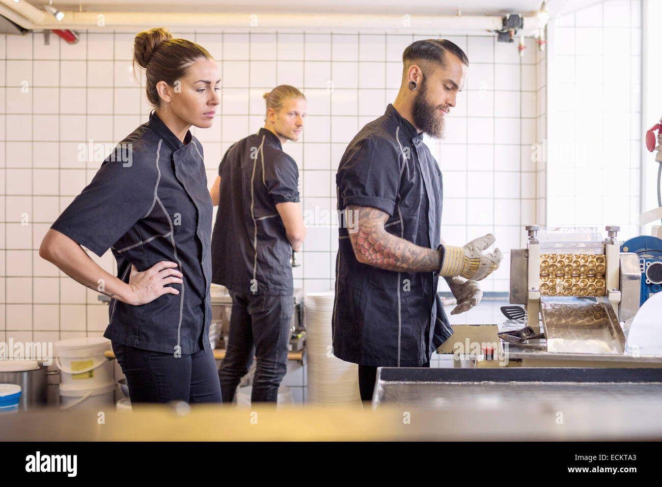Workers looking at candy machine in store Stock Photo - Alamy