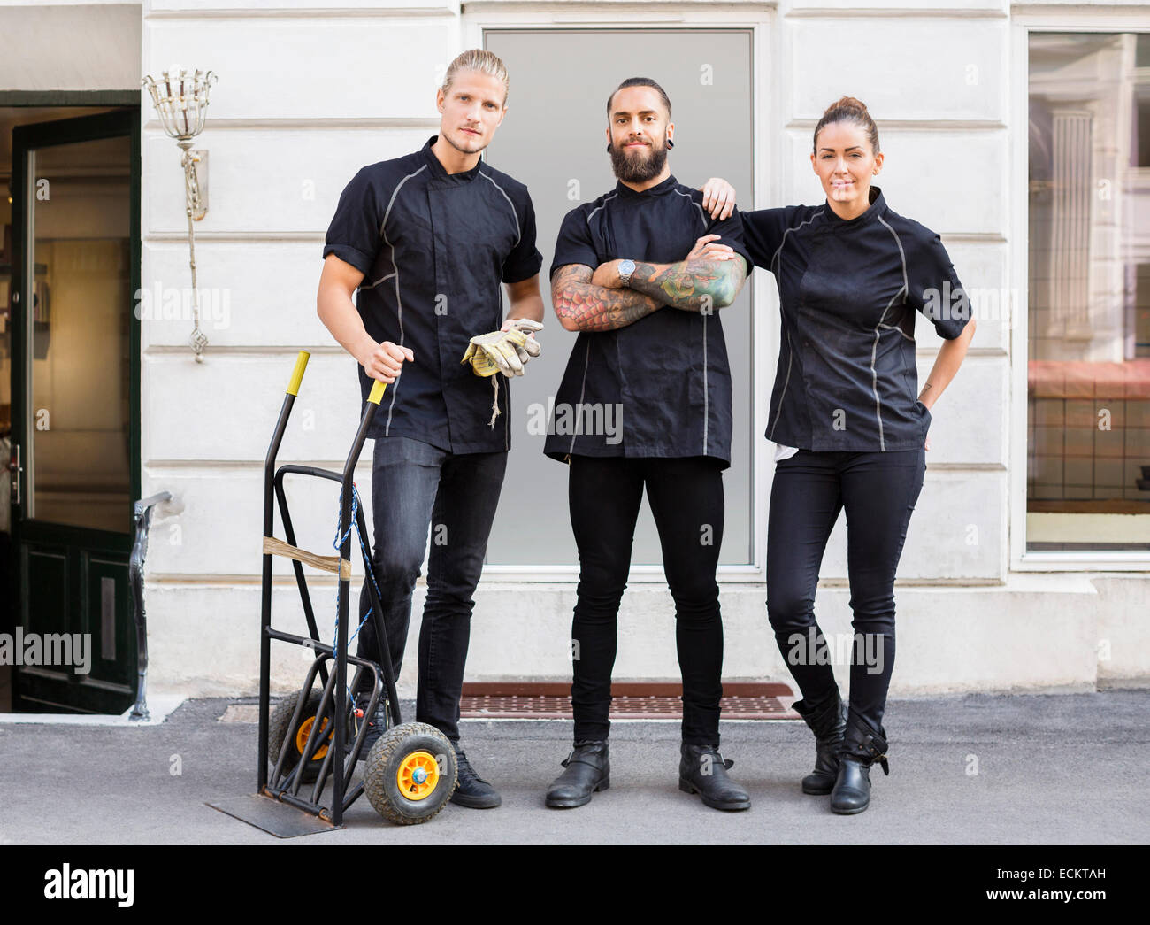 Portrait of workers standing on sidewalk outside candy store Stock ...