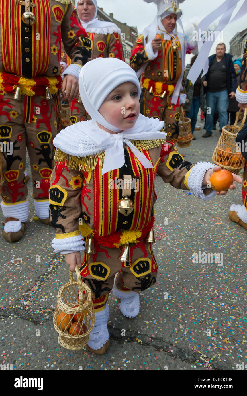 Young Gille holding out an orange during a procession through the ...
