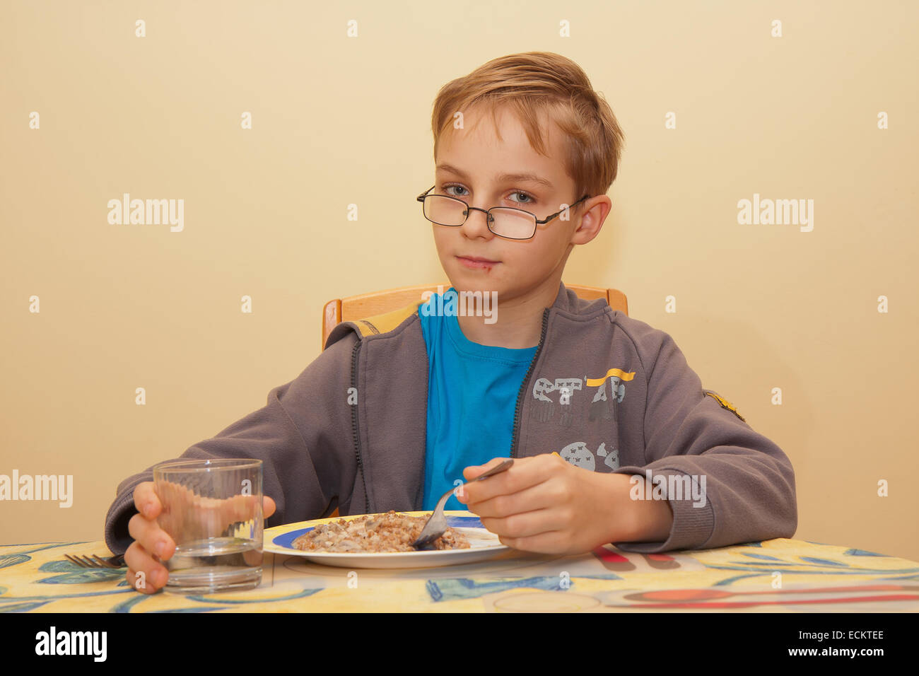 A small boy is eating his meal sitting at the table Stock Photo - Alamy