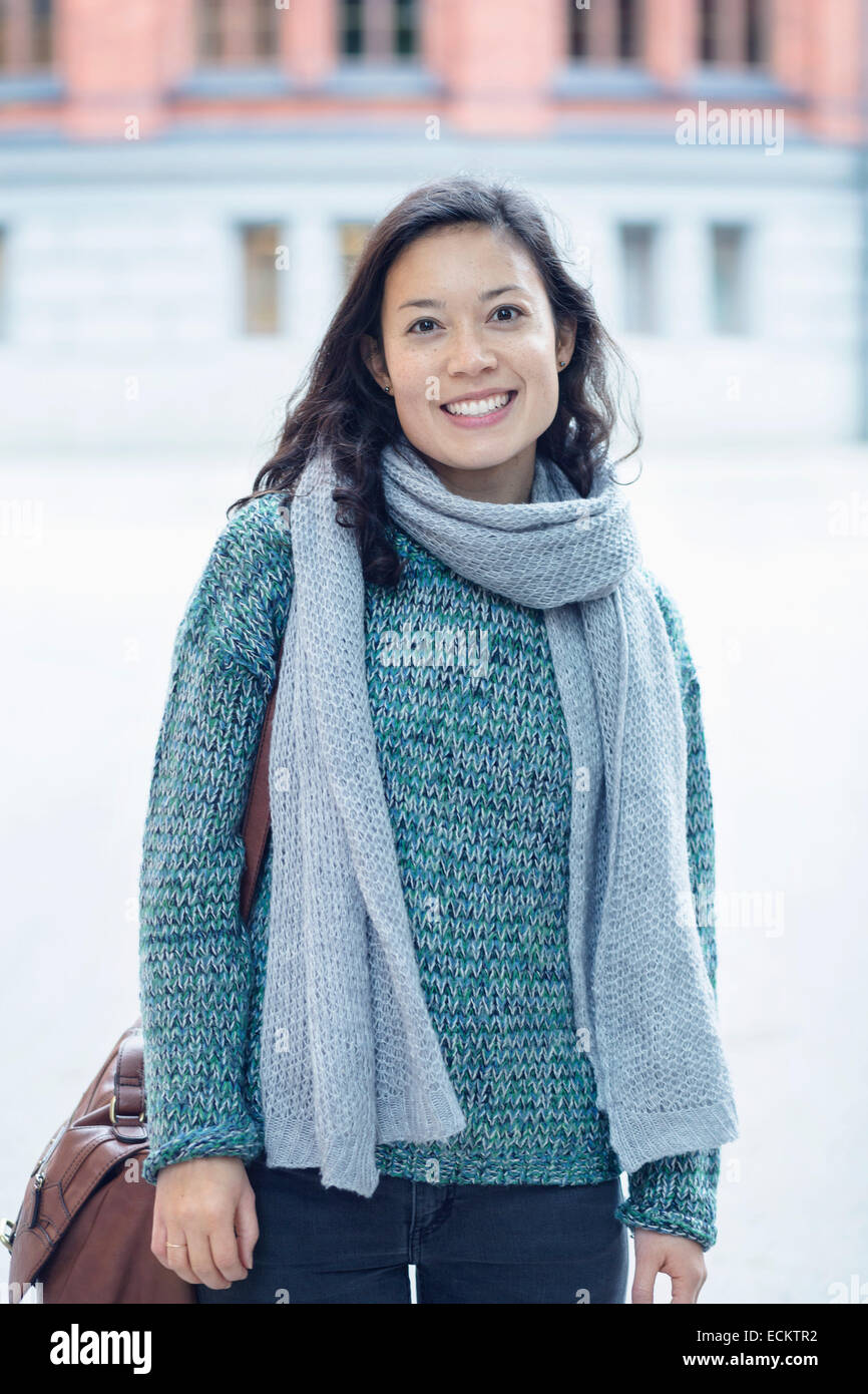 Portrait of smiling woman standing against building Stock Photo - Alamy