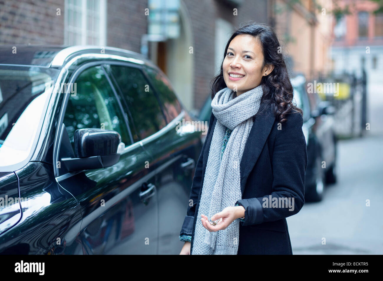 Portrait of smiling woman standing by car on street Stock Photo - Alamy
