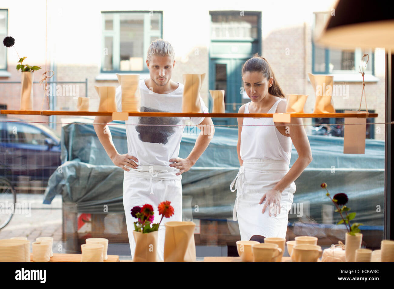 Workers looking at displayed crockeries in workshop from outside Stock ...