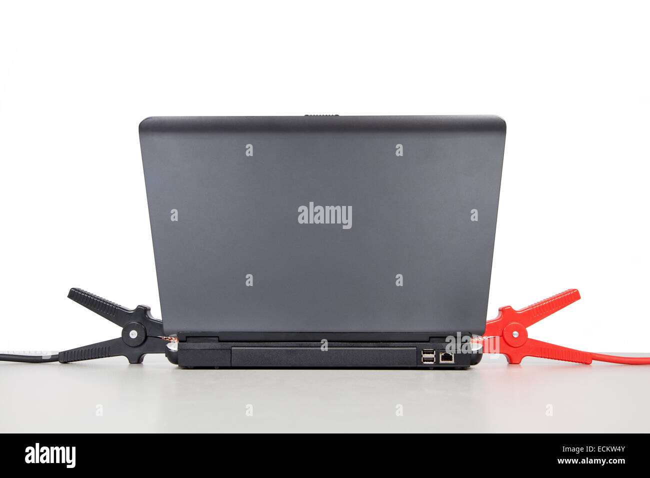 Laptop is charging by jumper cables on table Stock Photo - Alamy