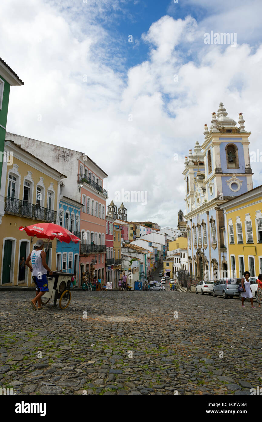 SALVADOR, BRAZIL - OCTOBER 15, 2013: A vendor walks in front of ...