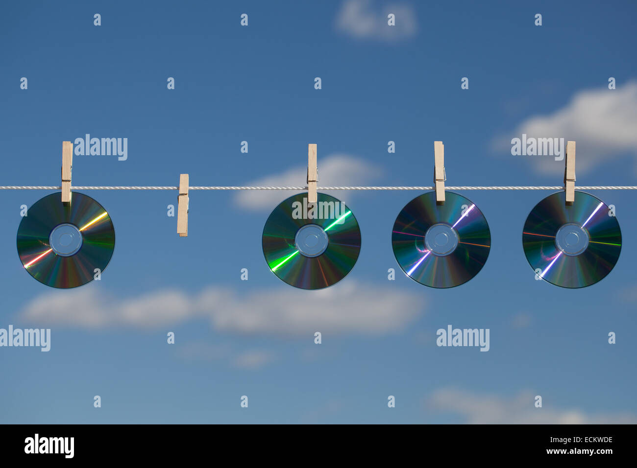 A missing CD in the row on a clothesline, attached with clothespins ...