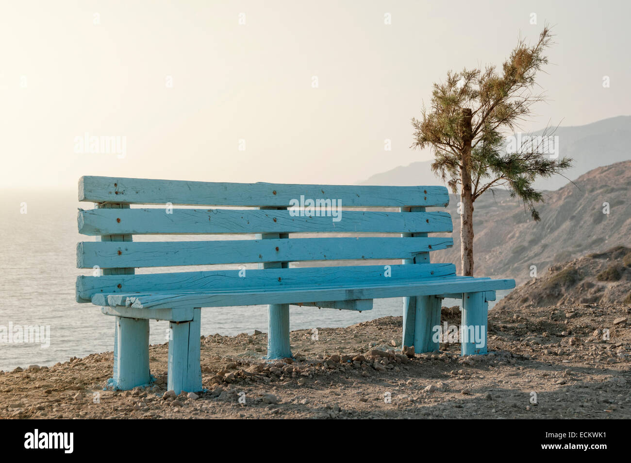 seascape at sunset with lonely blue bench Stock Photo - Alamy