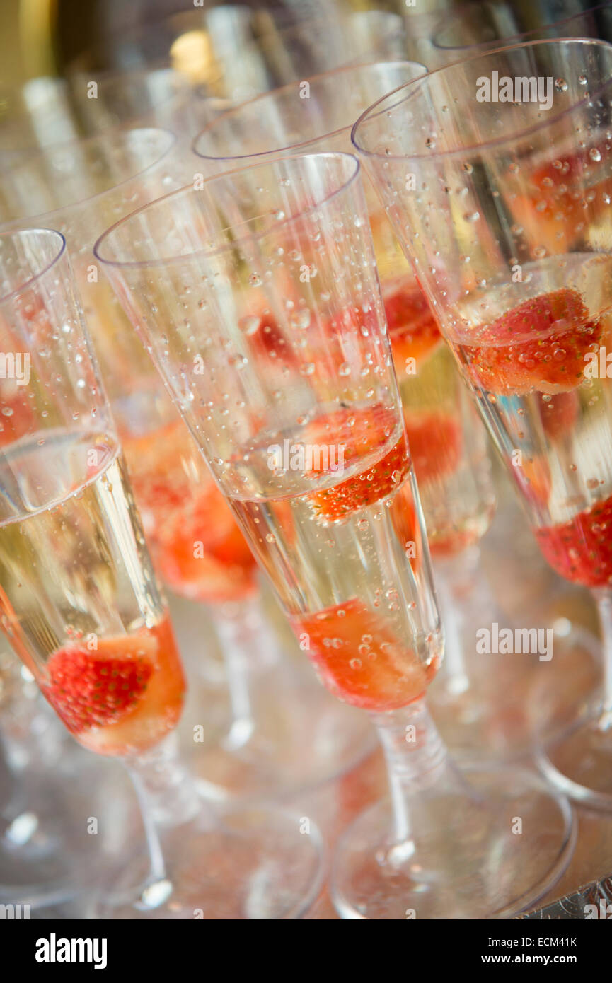 Glasses flutes of champagne or sparkling white wine with strawberries ...