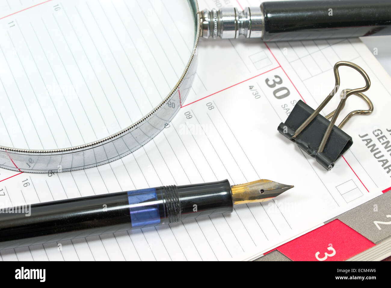 Fountain pen and magnifying glass on personal organizer Stock Photo - Alamy