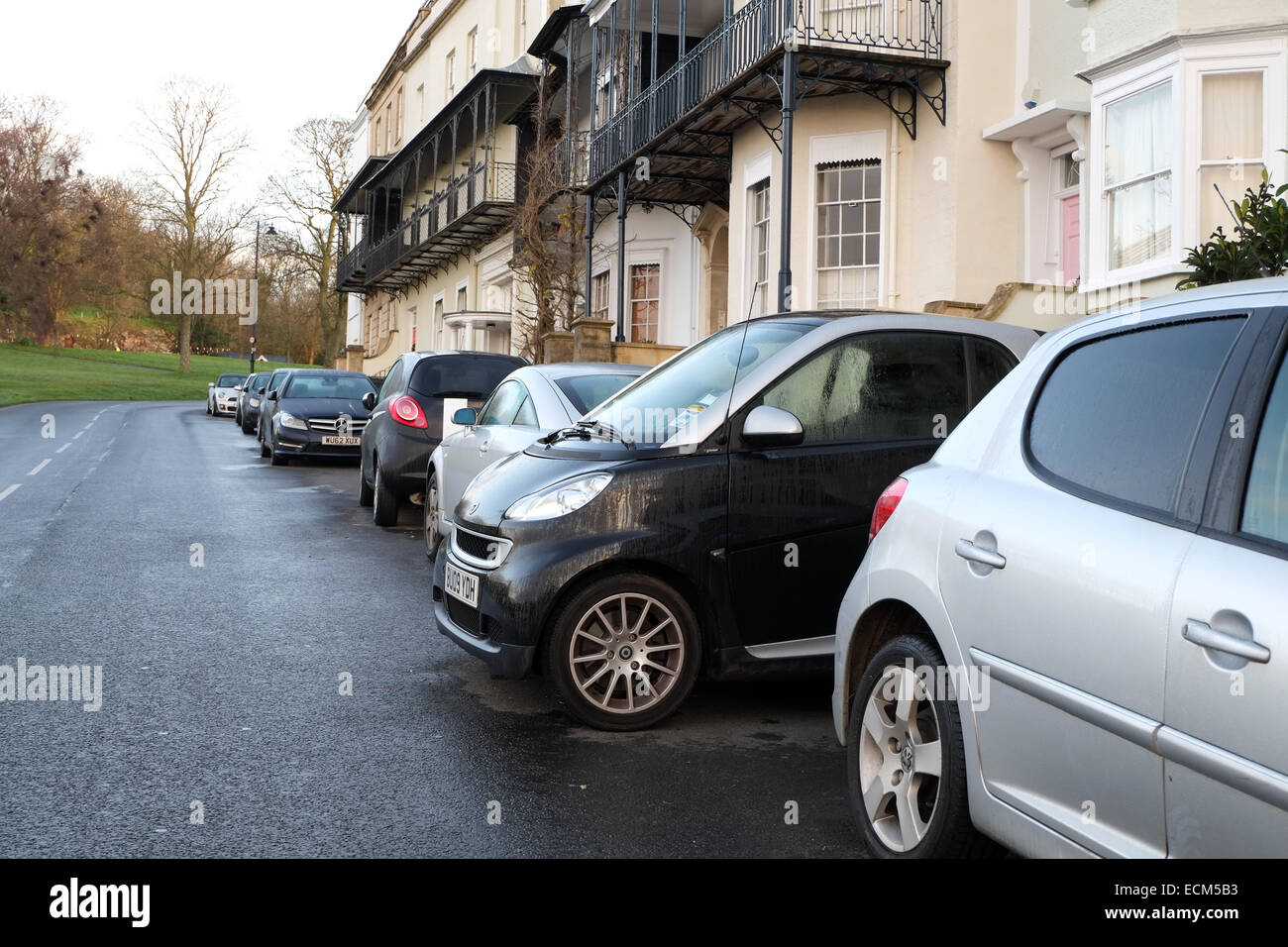 a very small Smart car parked end on into a small parking space in the ...