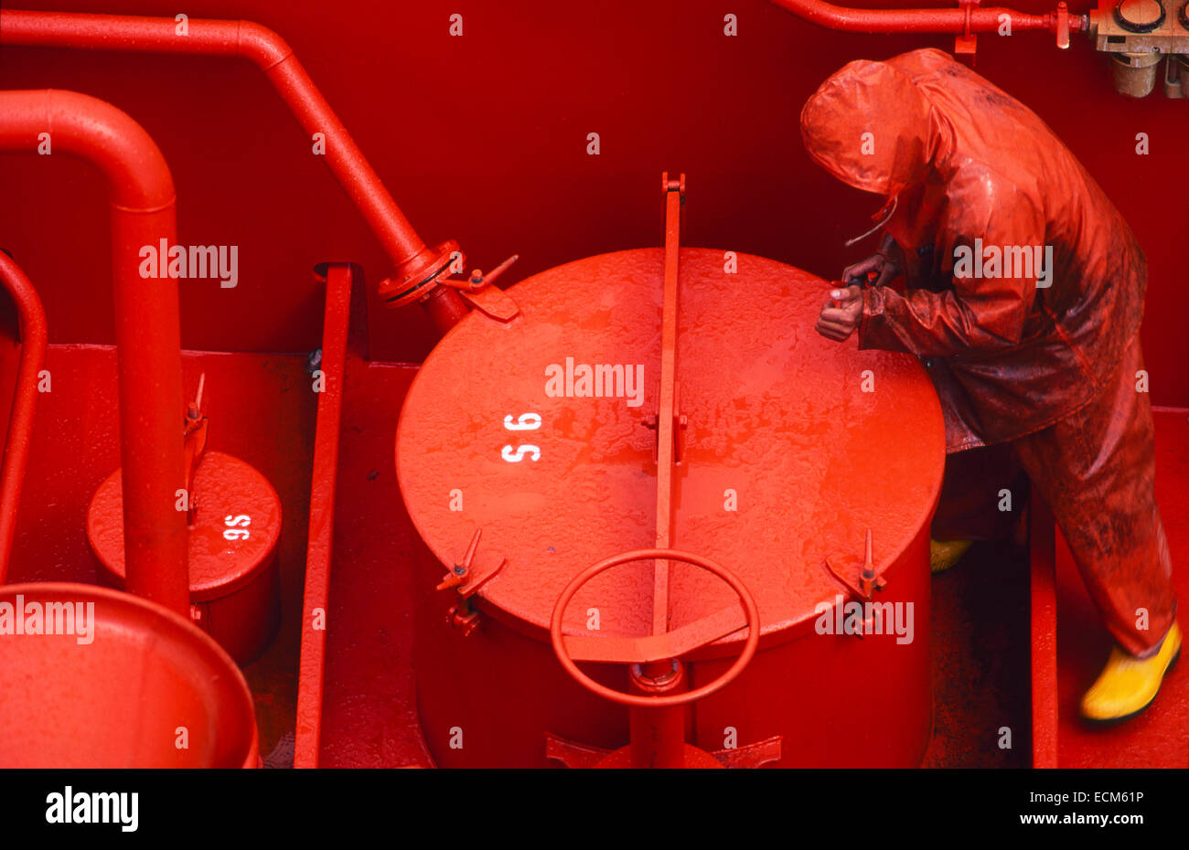 Workers secure holds, hatches and equipment on the orange deck of an ...