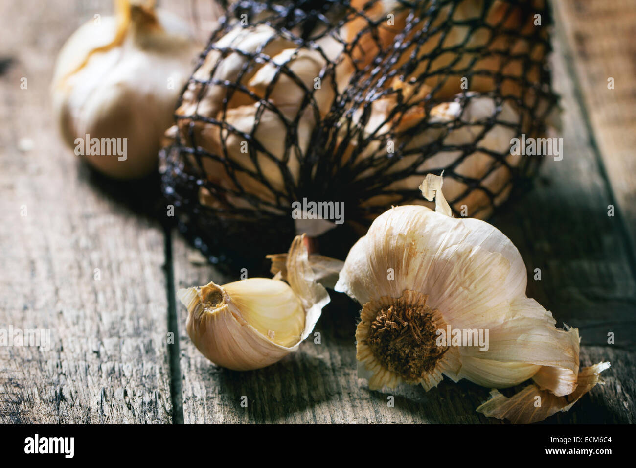 Mesh bag of smoked garlic over wooden background. See series Stock ...
