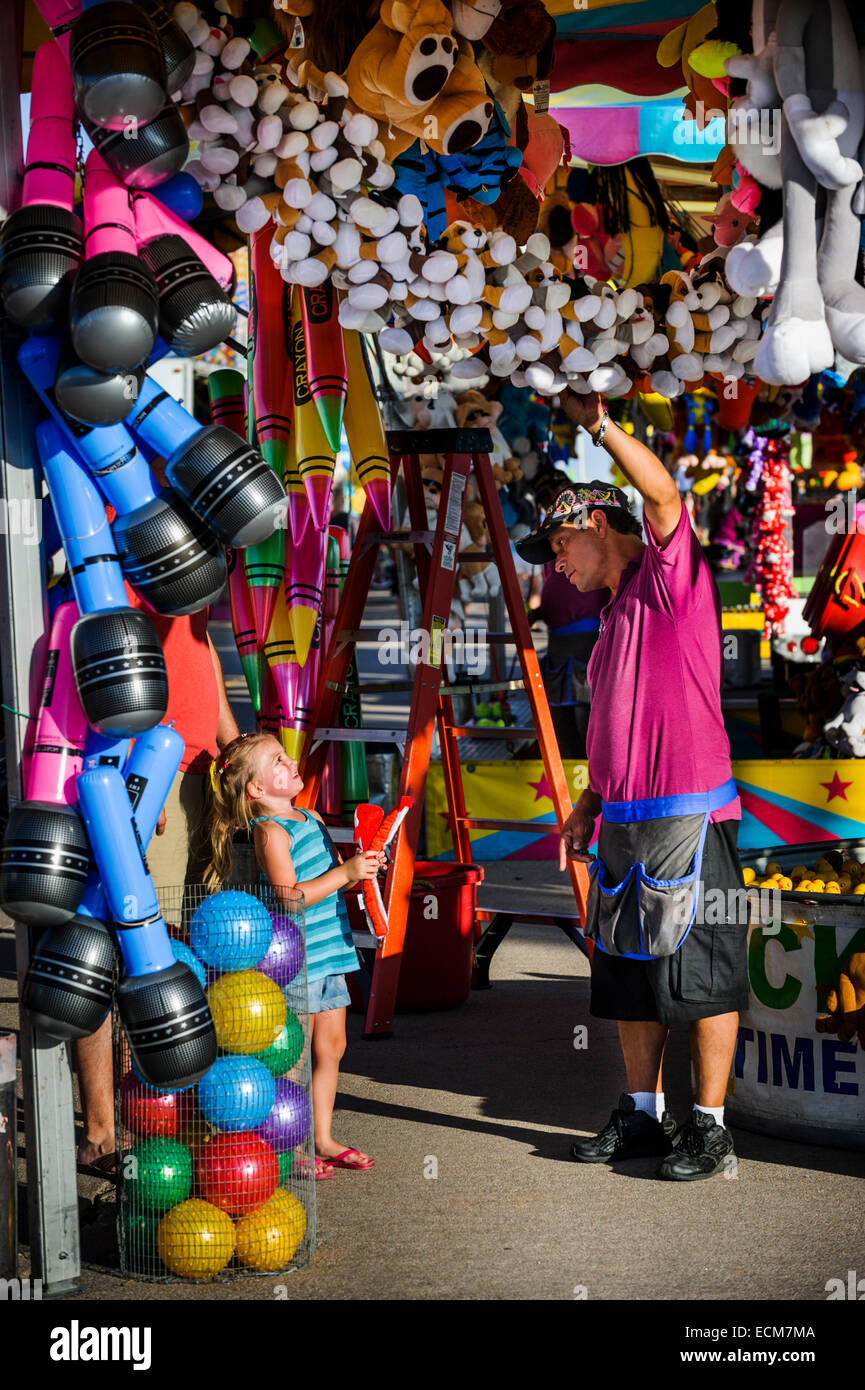 a young girl choosing a prize at a carnival Stock Photo - Alamy