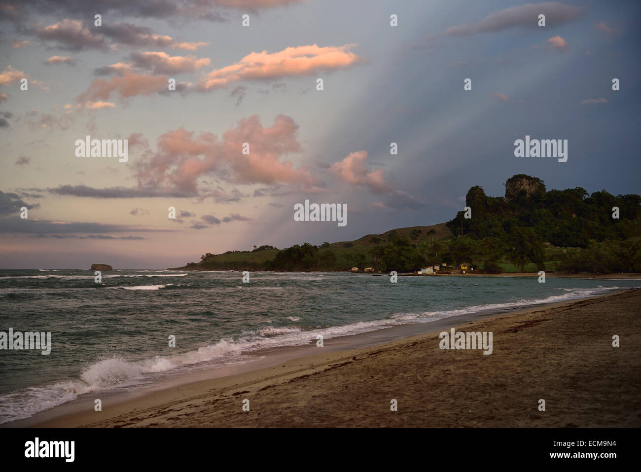 Pink light sun rays and clouds at sunset with waves on the beach of ...