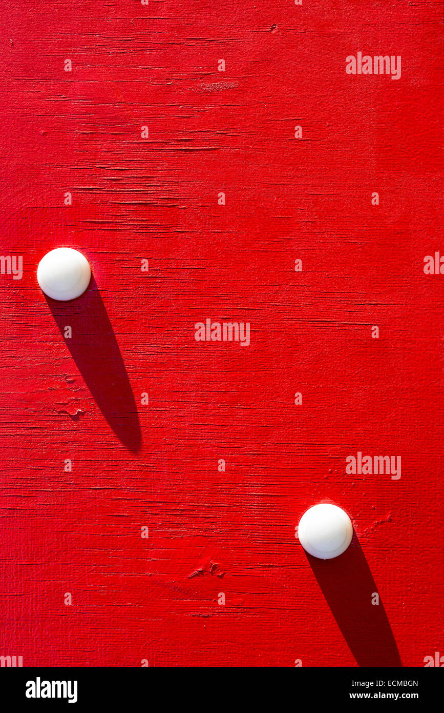 Two white buttons on a wooden surface painted red Stock Photo - Alamy
