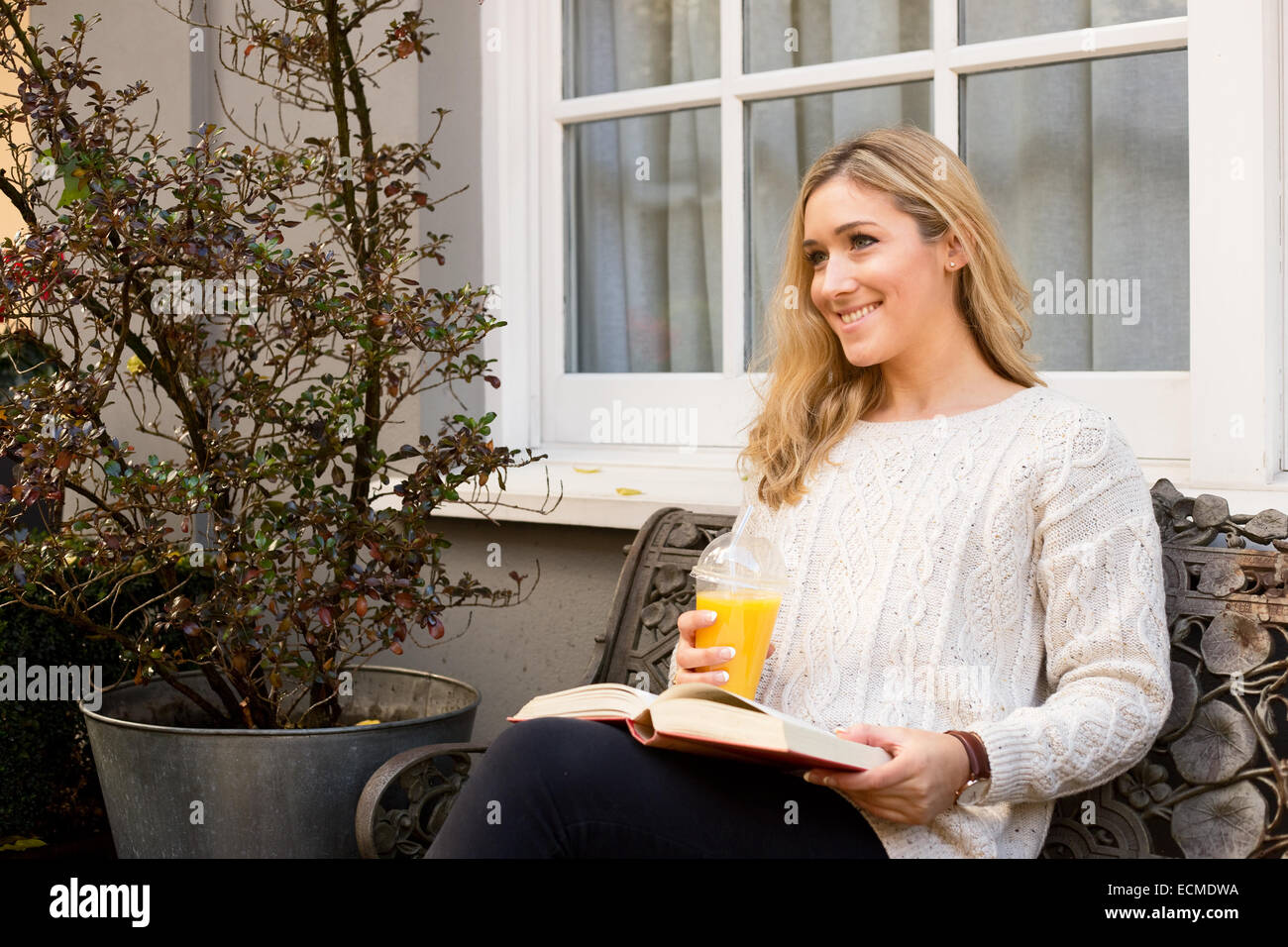 young woman reading a book with a drink Stock Photo - Alamy
