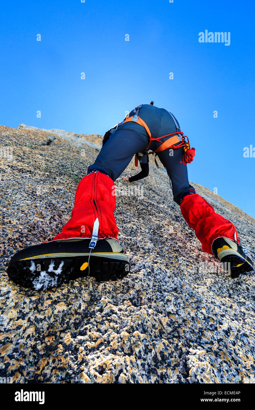 Climber climbing on a rock wall, alpine climb, Alps, below the summit ...