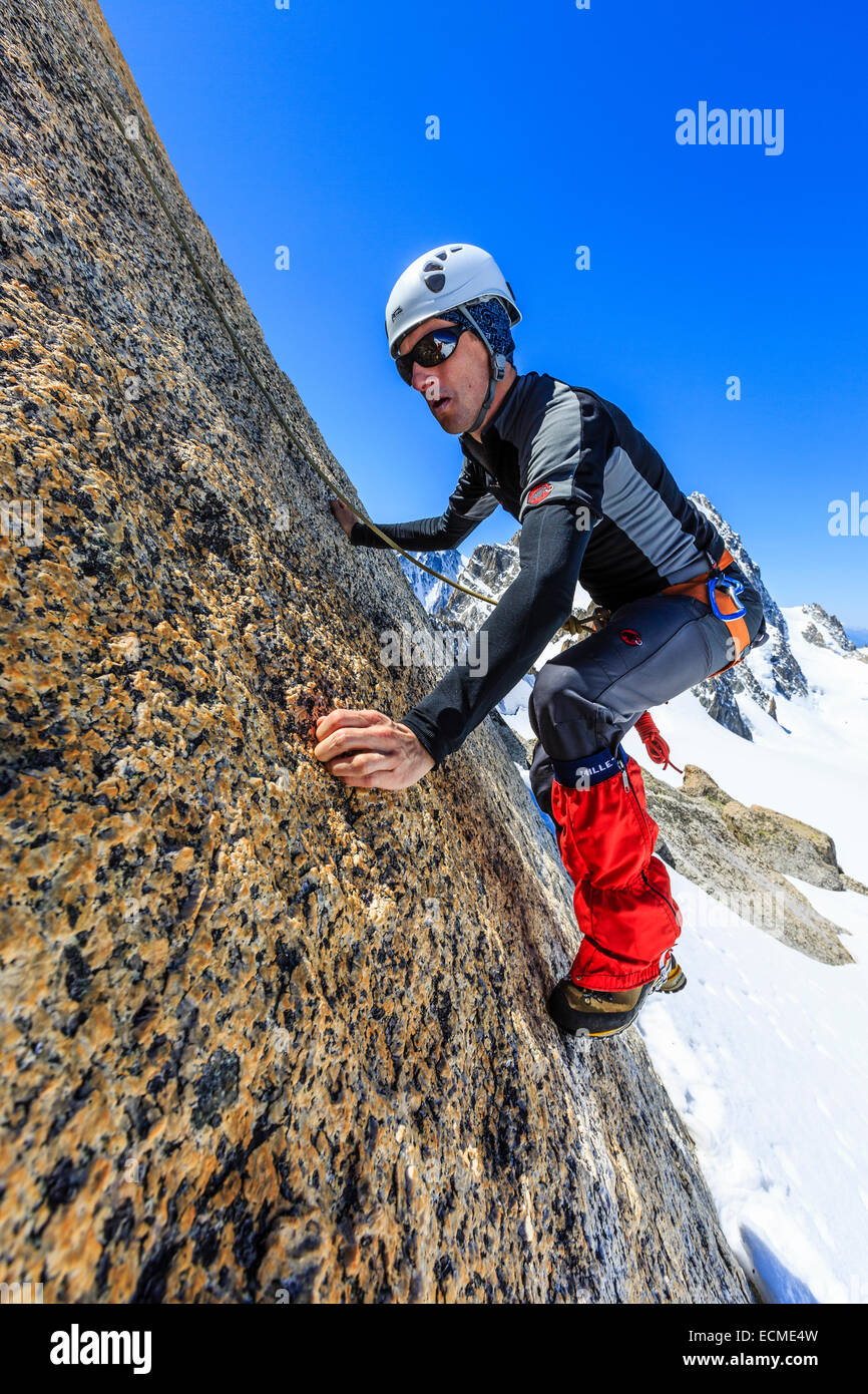 Climber climbing on a rock wall, alpine climb, Alps, below the summit ...