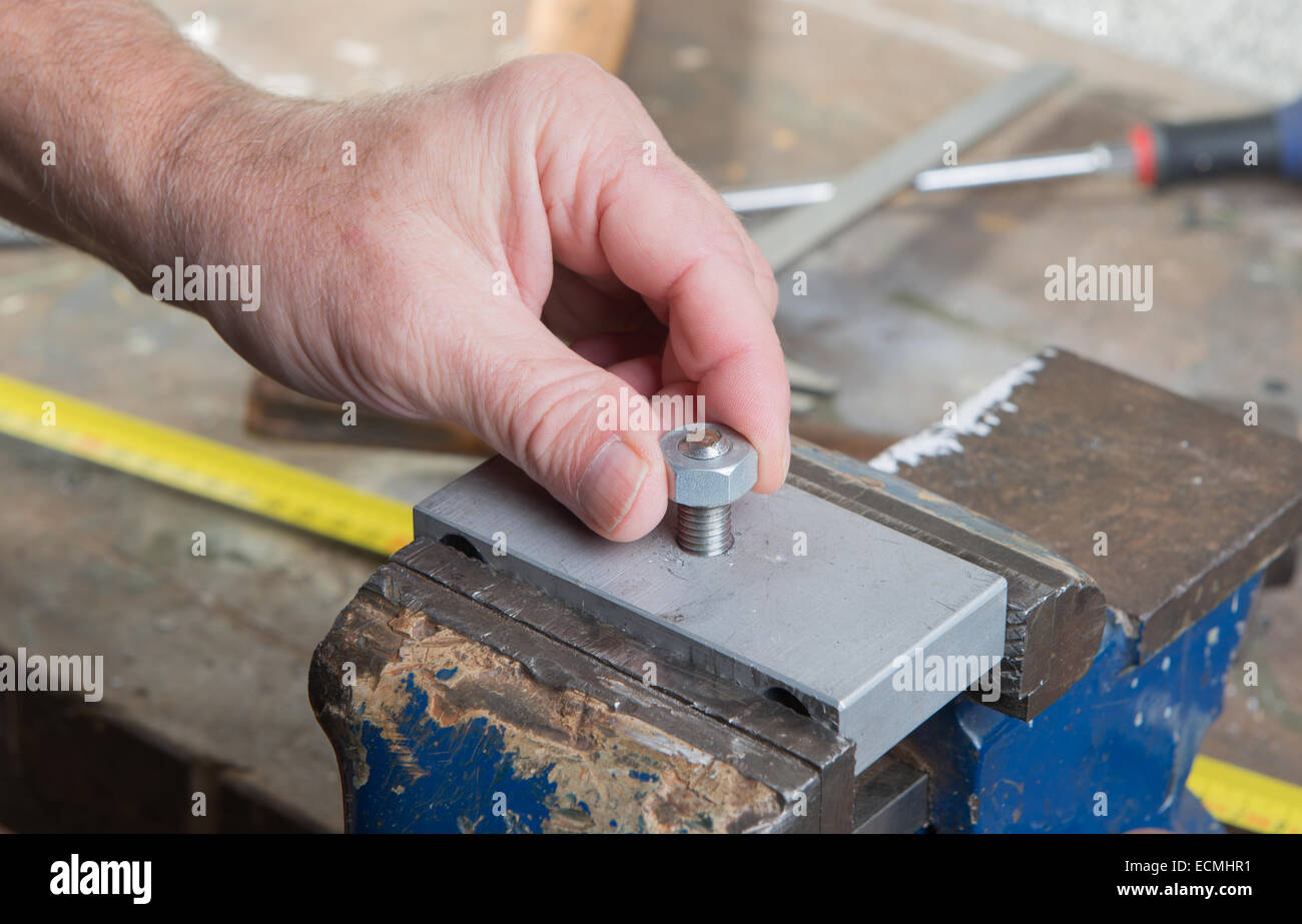 a man screw a nut with hand Stock Photo - Alamy