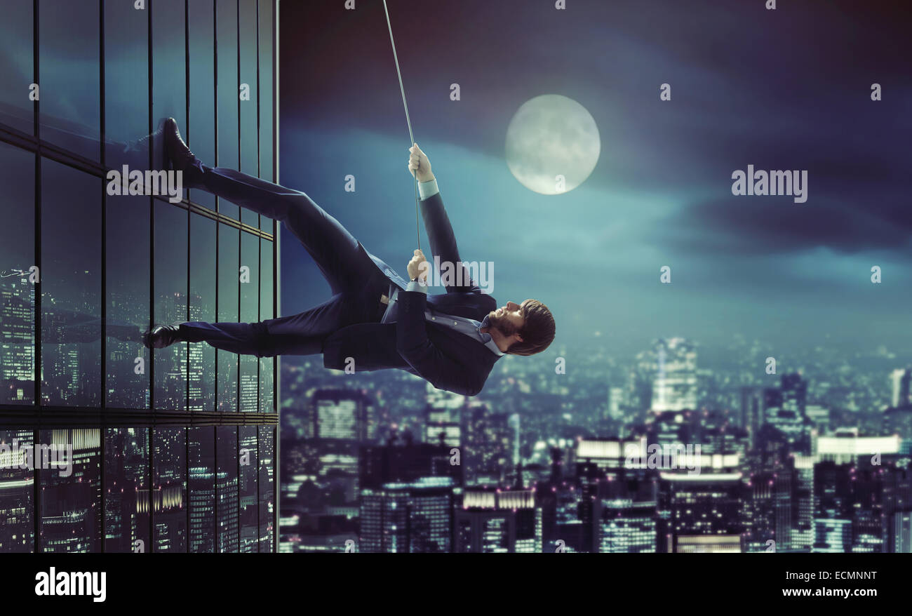 Young man climbing on the high skyscraper Stock Photo - Alamy