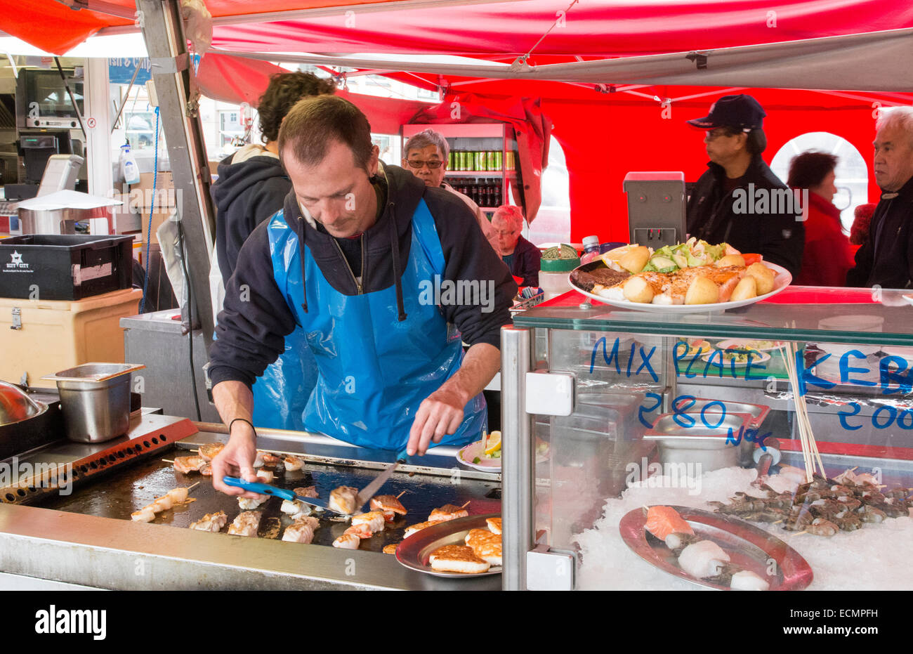 Bergen Norway seafood outdoor cafe cook prepares seafood for tourists ...