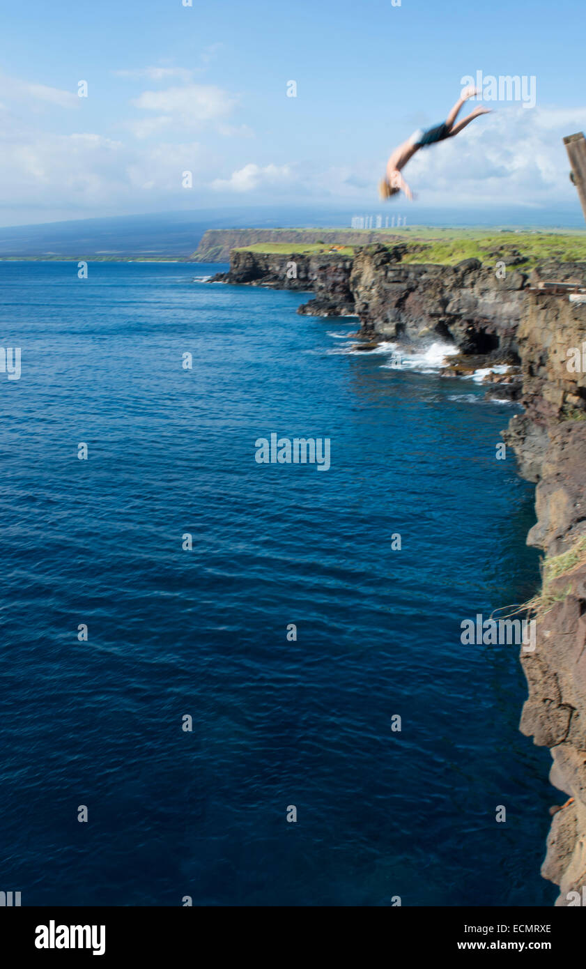 South Point Hawaii Big Island cliff pole young man diving intp water ...