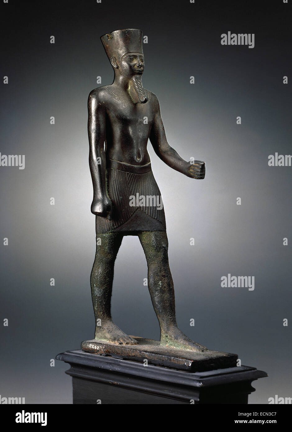 Egyptian Art. Bronze statuette depicting the god Amun standing with leg ...