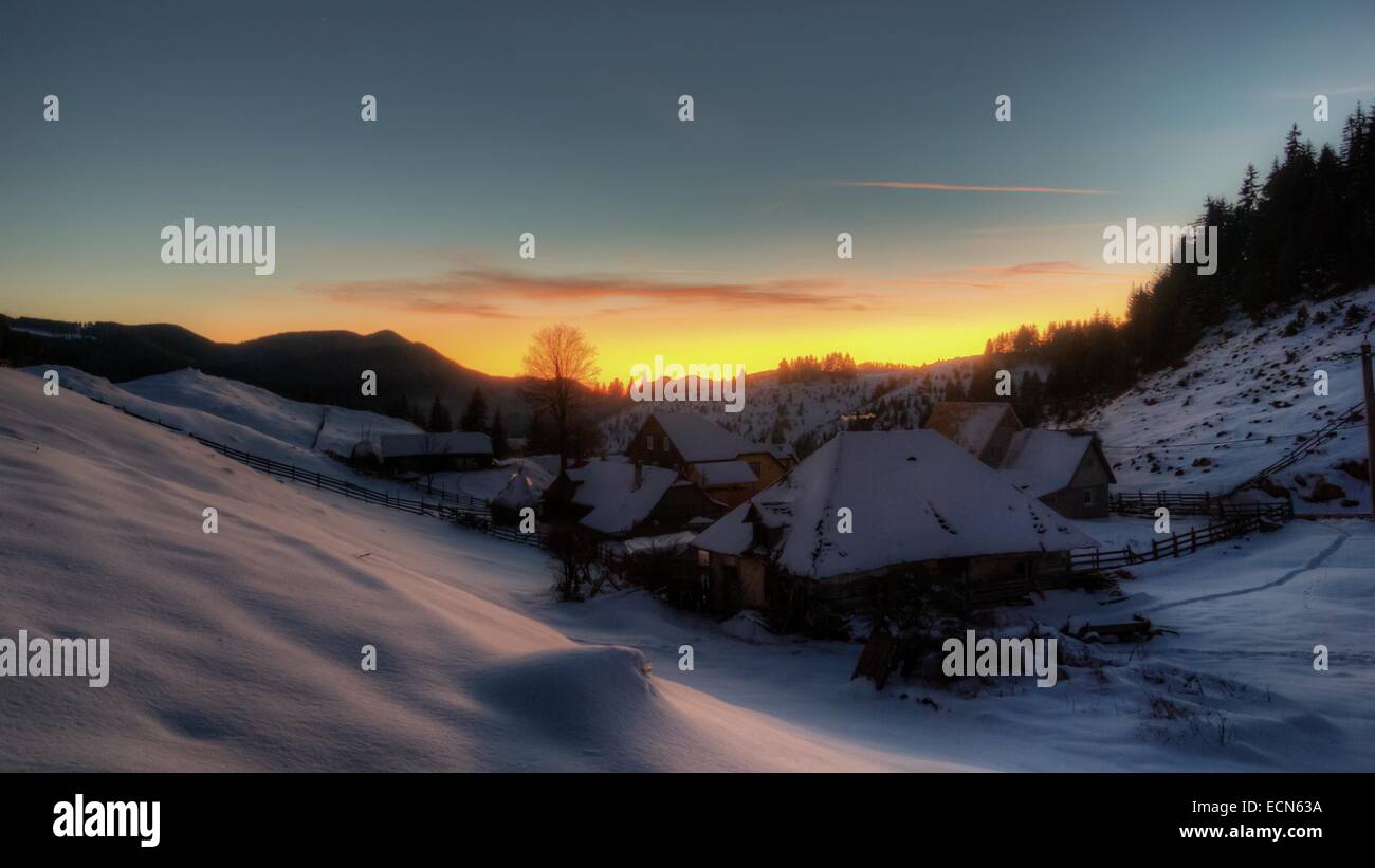 Winter sunset over village of Fundata. Mountain landscape with houses ...