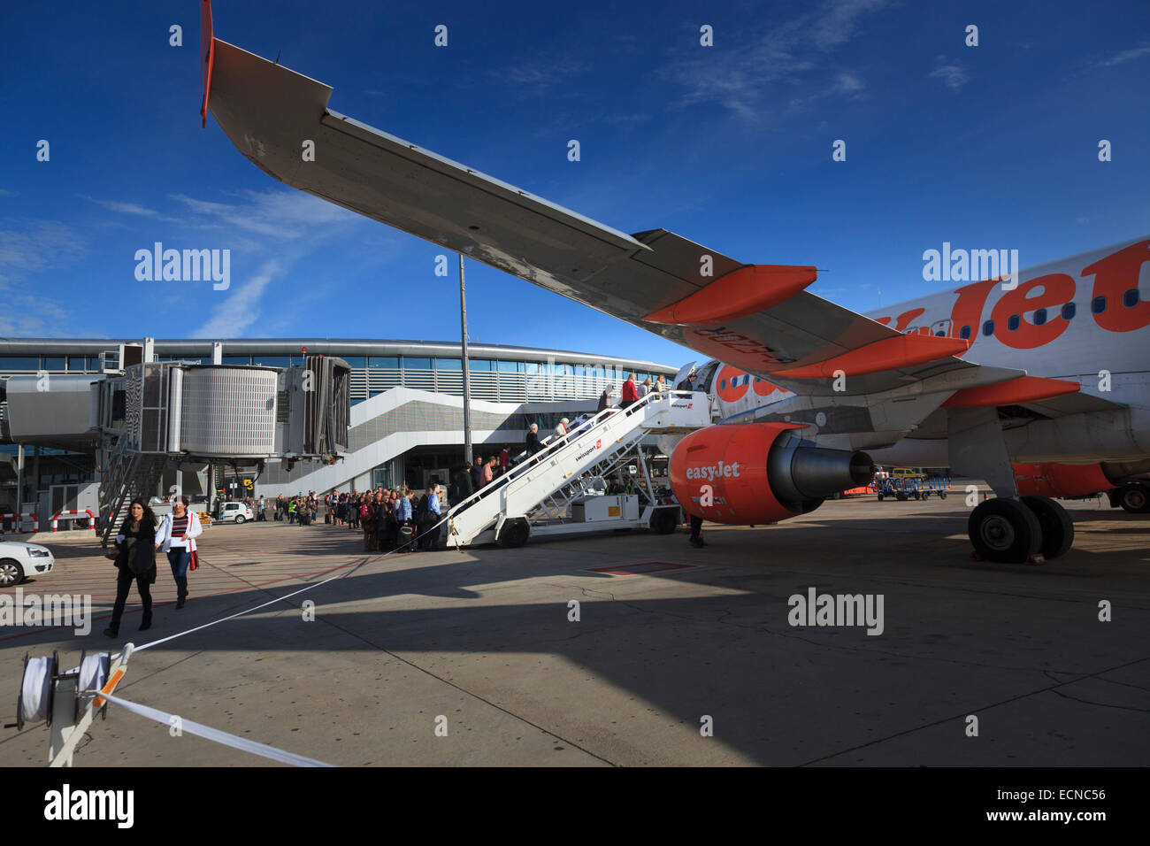 Passengers using the front aircraft stairs to board an Easyjet aircraft ...