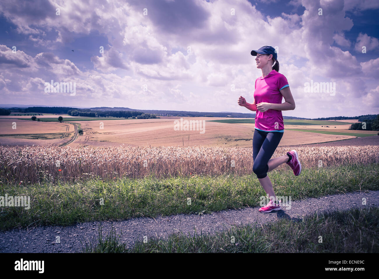 a woman running through the rural landscape Stock Photo - Alamy