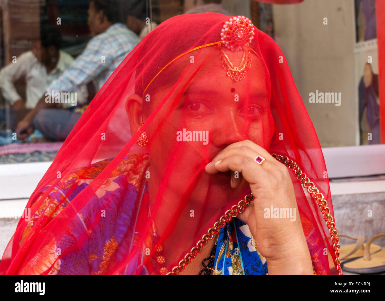 Woman hides her face with red veil Stock Photo - Alamy