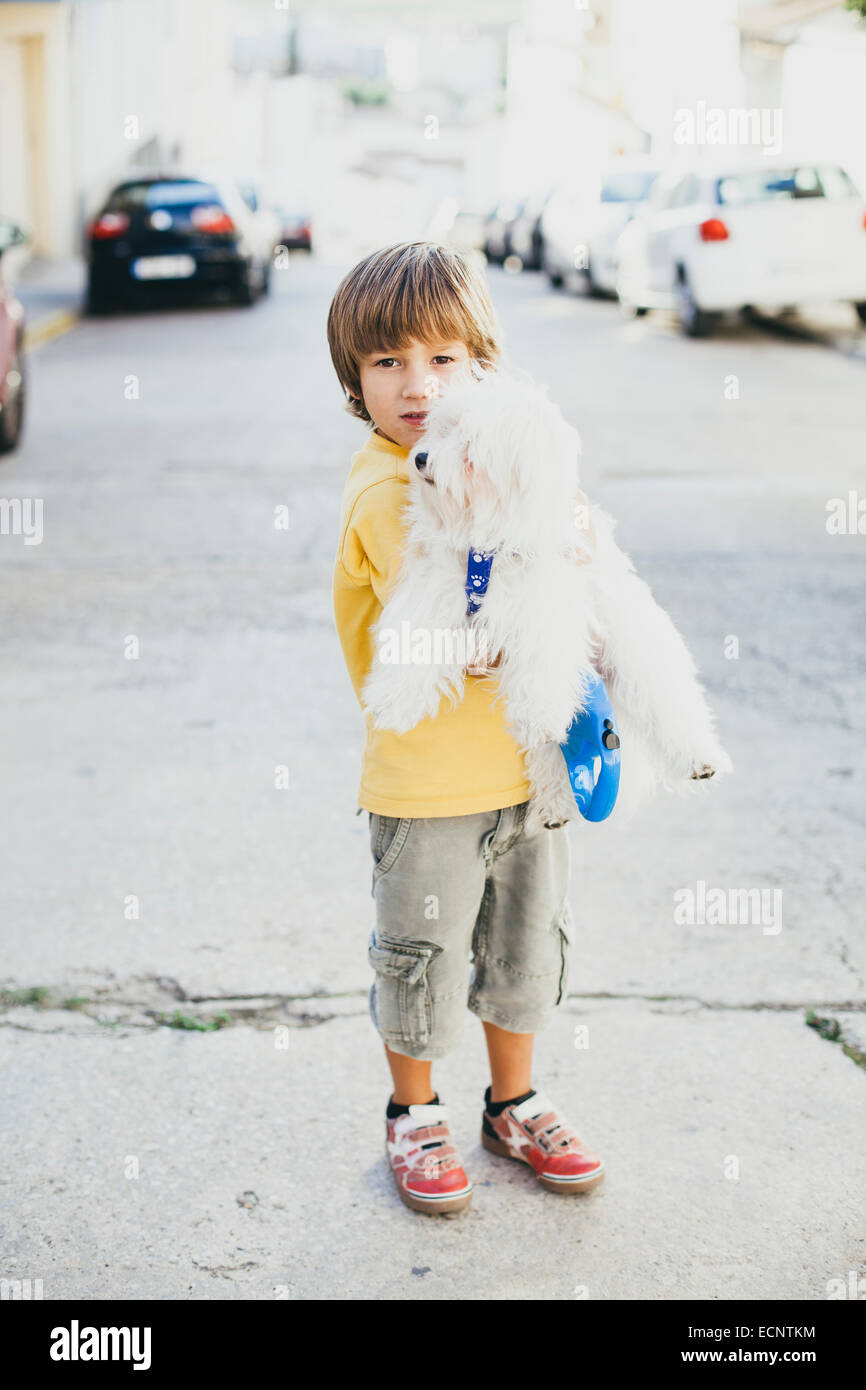 Boy with a white small dog Stock Photo - Alamy