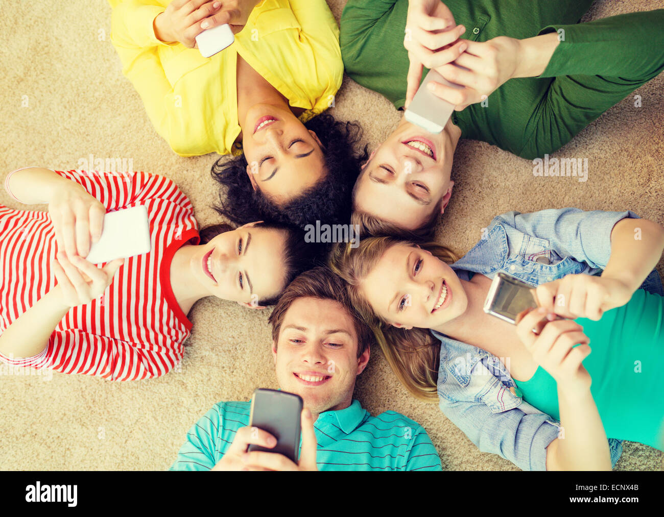 group of smiling people lying down on floor Stock Photo - Alamy