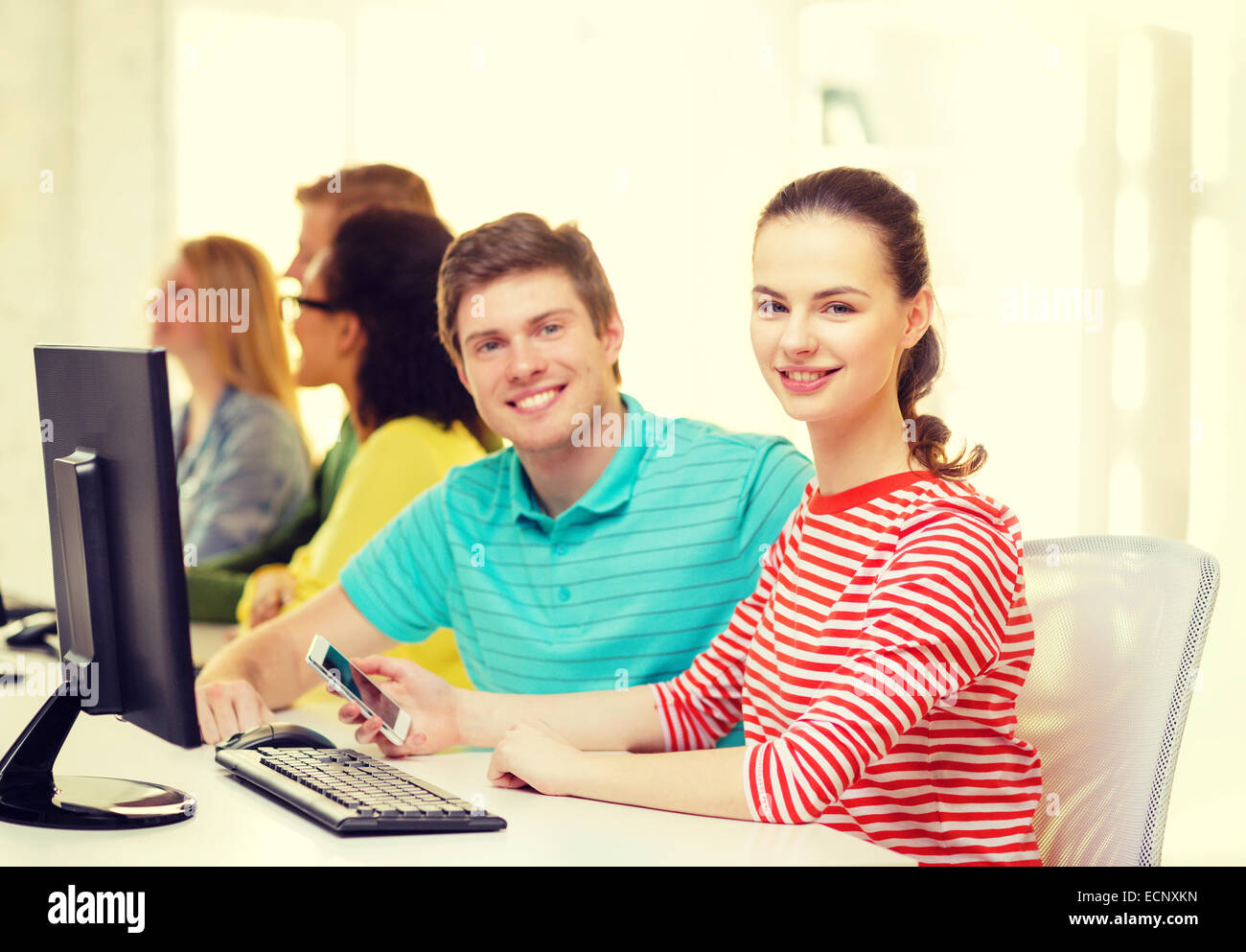 smiling student with smartphone in computer class Stock Photo - Alamy