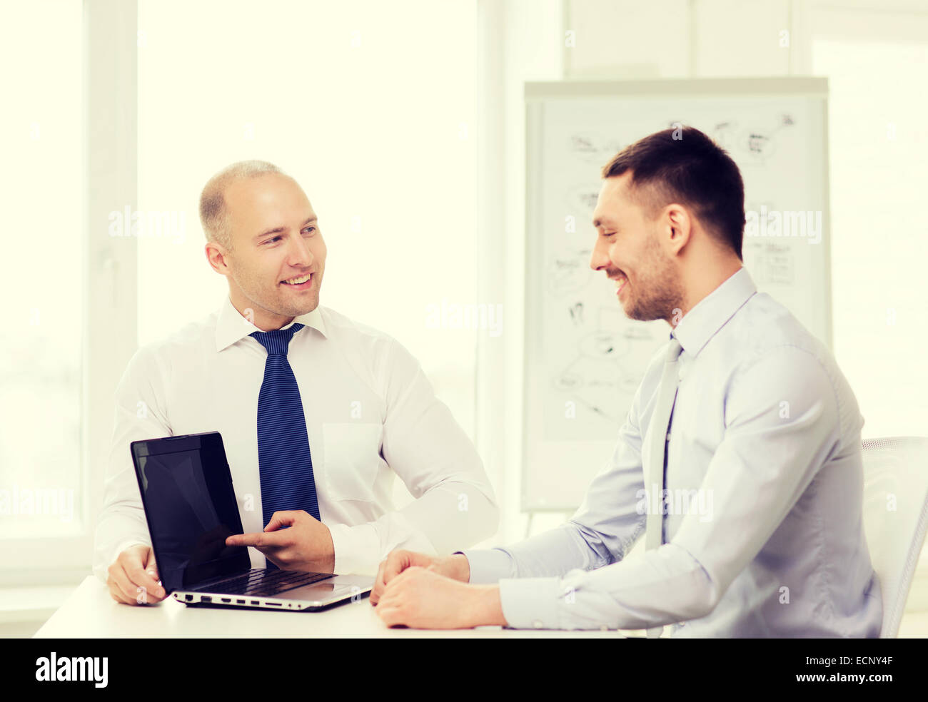 two smiling businessmen with laptop in office Stock Photo - Alamy