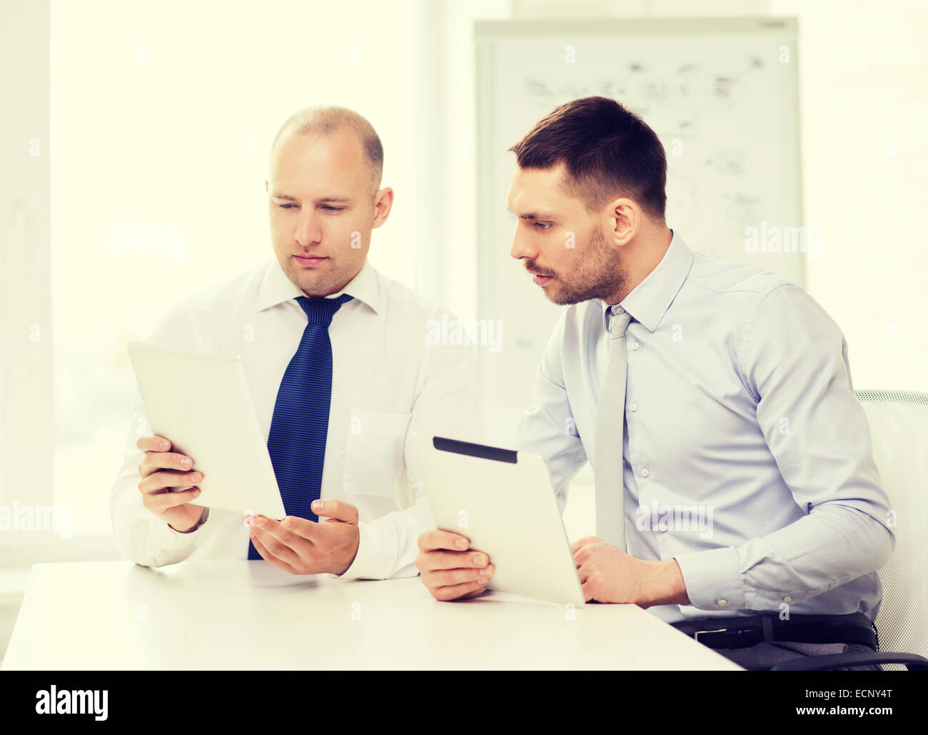 two serious businessmen with tablet pc in office Stock Photo - Alamy
