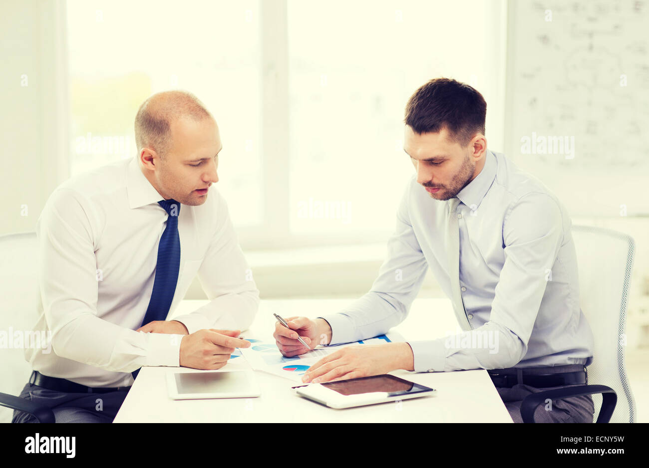 two serious businessmen with tablet pc in office Stock Photo - Alamy