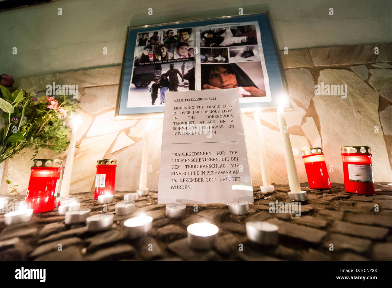 Berlin, Germany. 17th Dec, 2014. Candles are lit in front of photos of ...