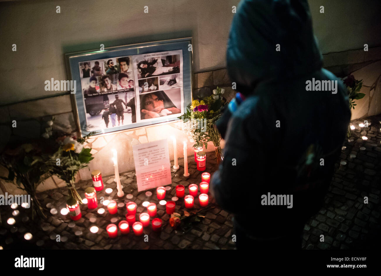 Berlin, Germany. 17th Dec, 2014. Candles are lit in front of photos of ...