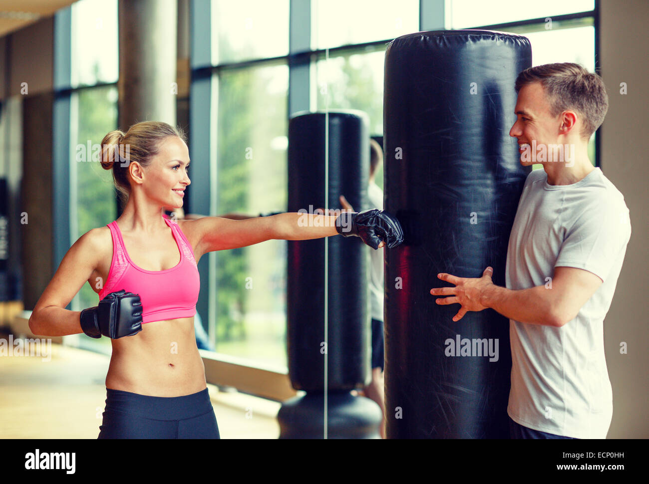 smiling woman with personal trainer boxing in gym Stock Photo - Alamy