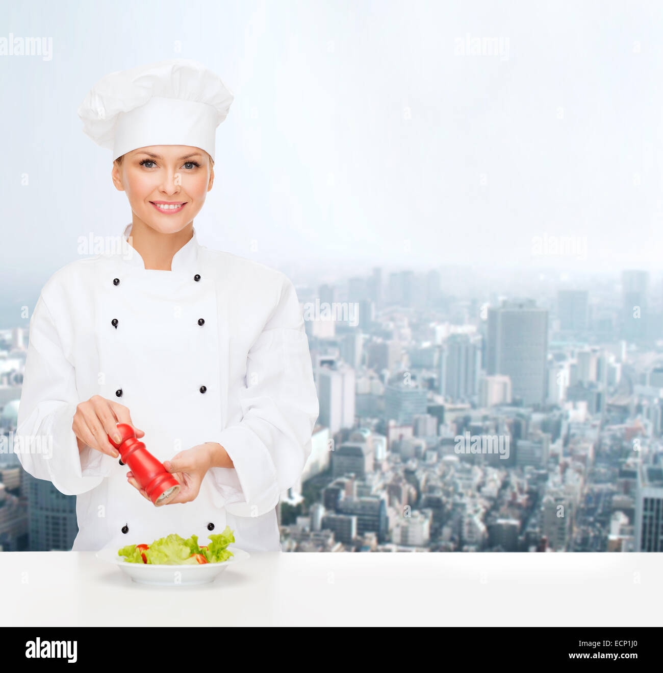 smiling female chef spicing vegetable salad Stock Photo - Alamy