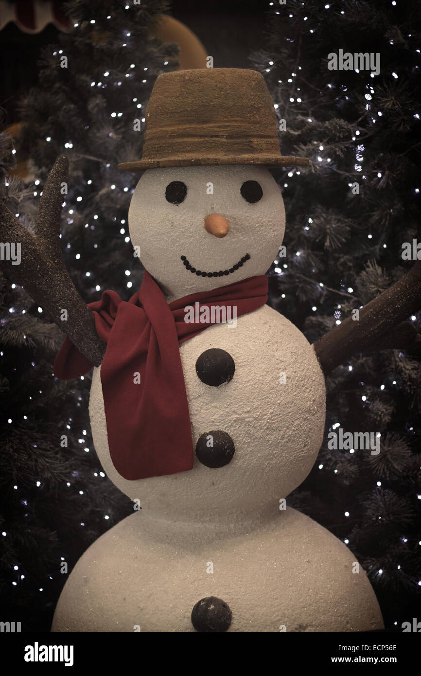 A Christmas decorative snowman wearing a scarf with a tree behind Stock ...