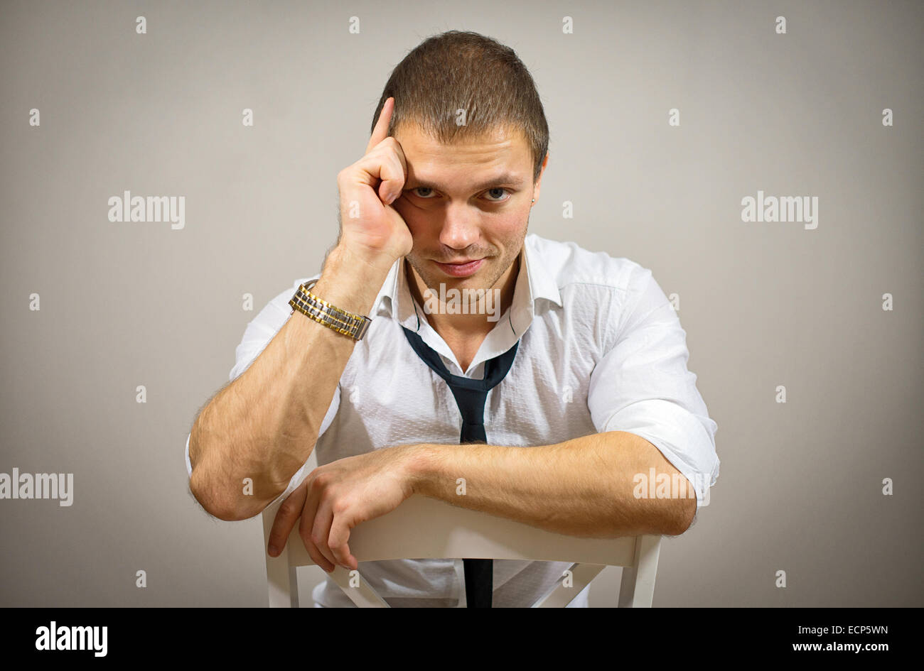 Handsome male model sitting on the chair Stock Photo - Alamy