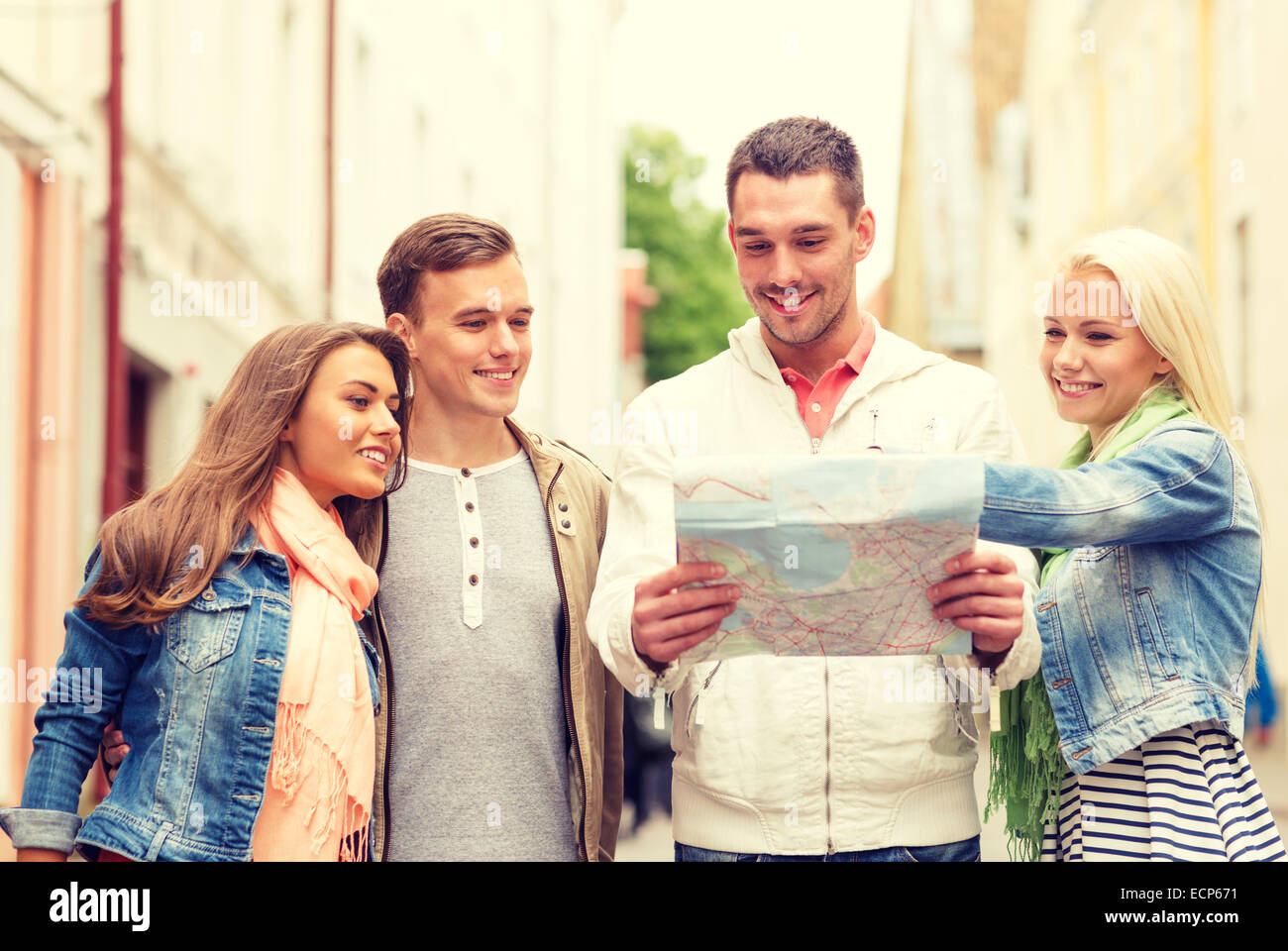 group of smiling friends with map exploring city Stock Photo - Alamy