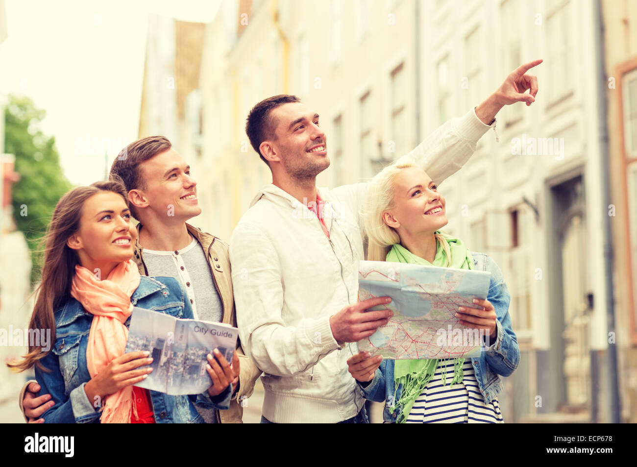 group of smiling friends with city guide and map Stock Photo - Alamy