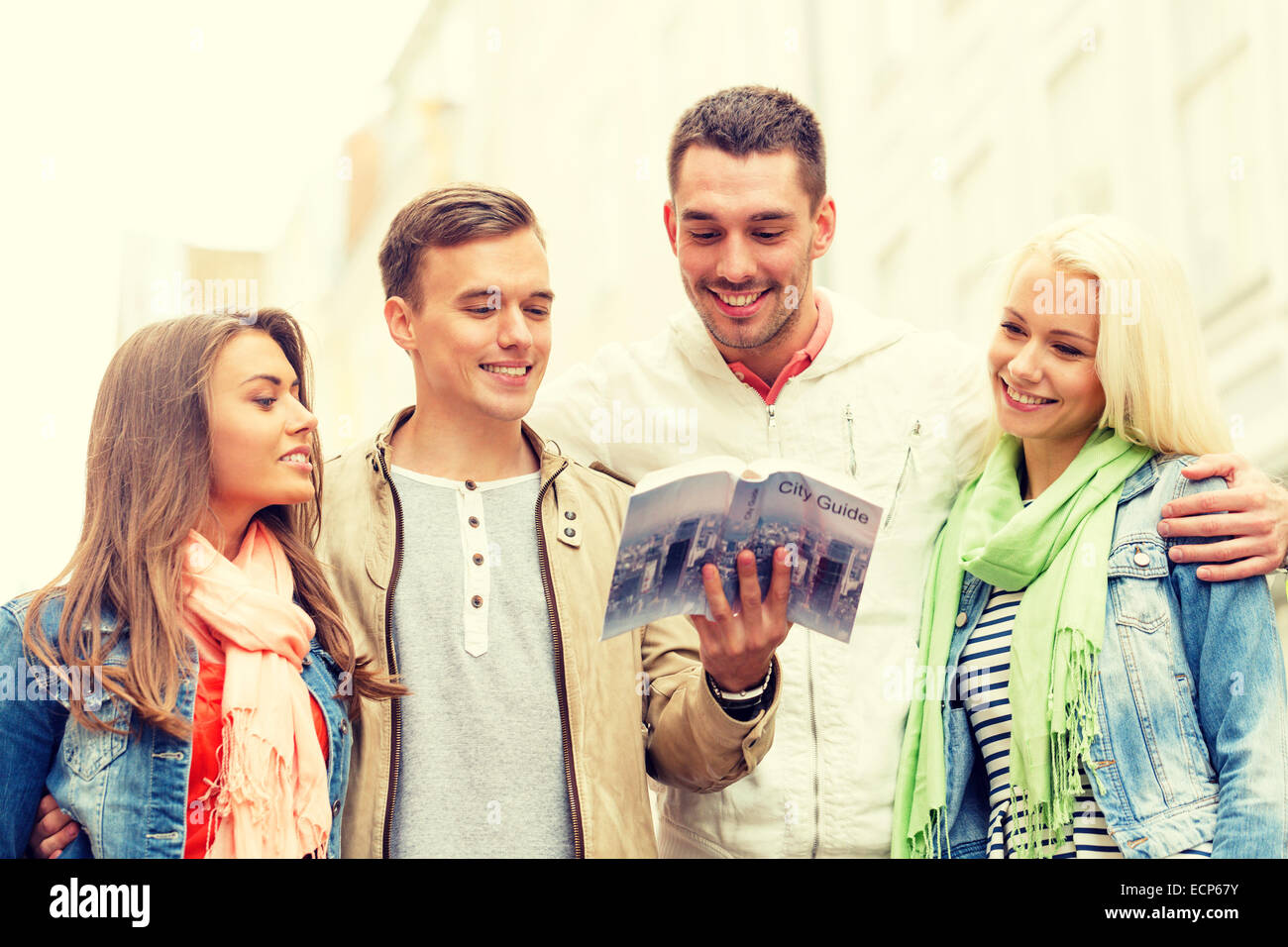 group of friends with city guide exploring town Stock Photo - Alamy