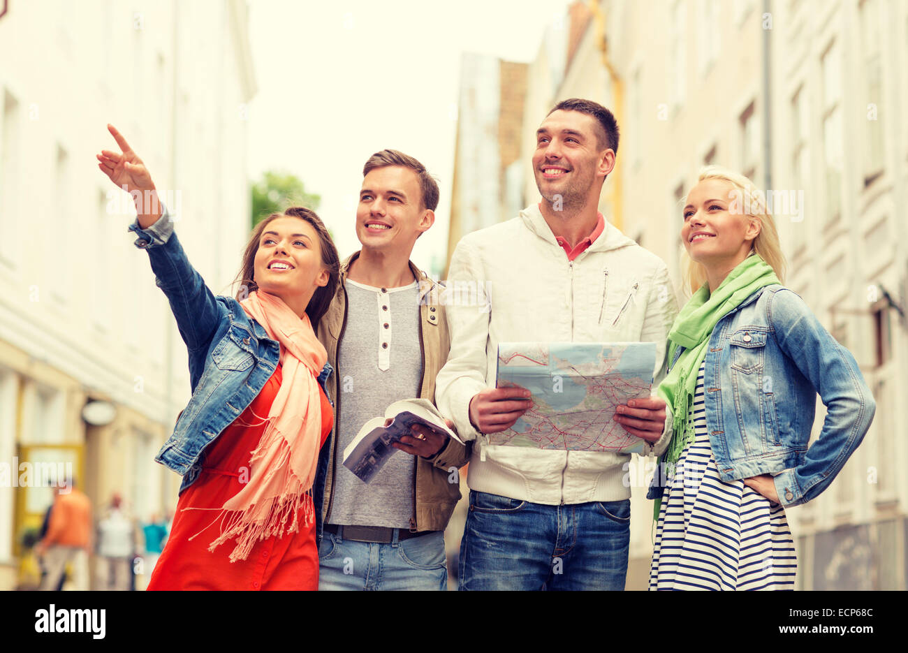 group of smiling friends with city guide and map Stock Photo - Alamy