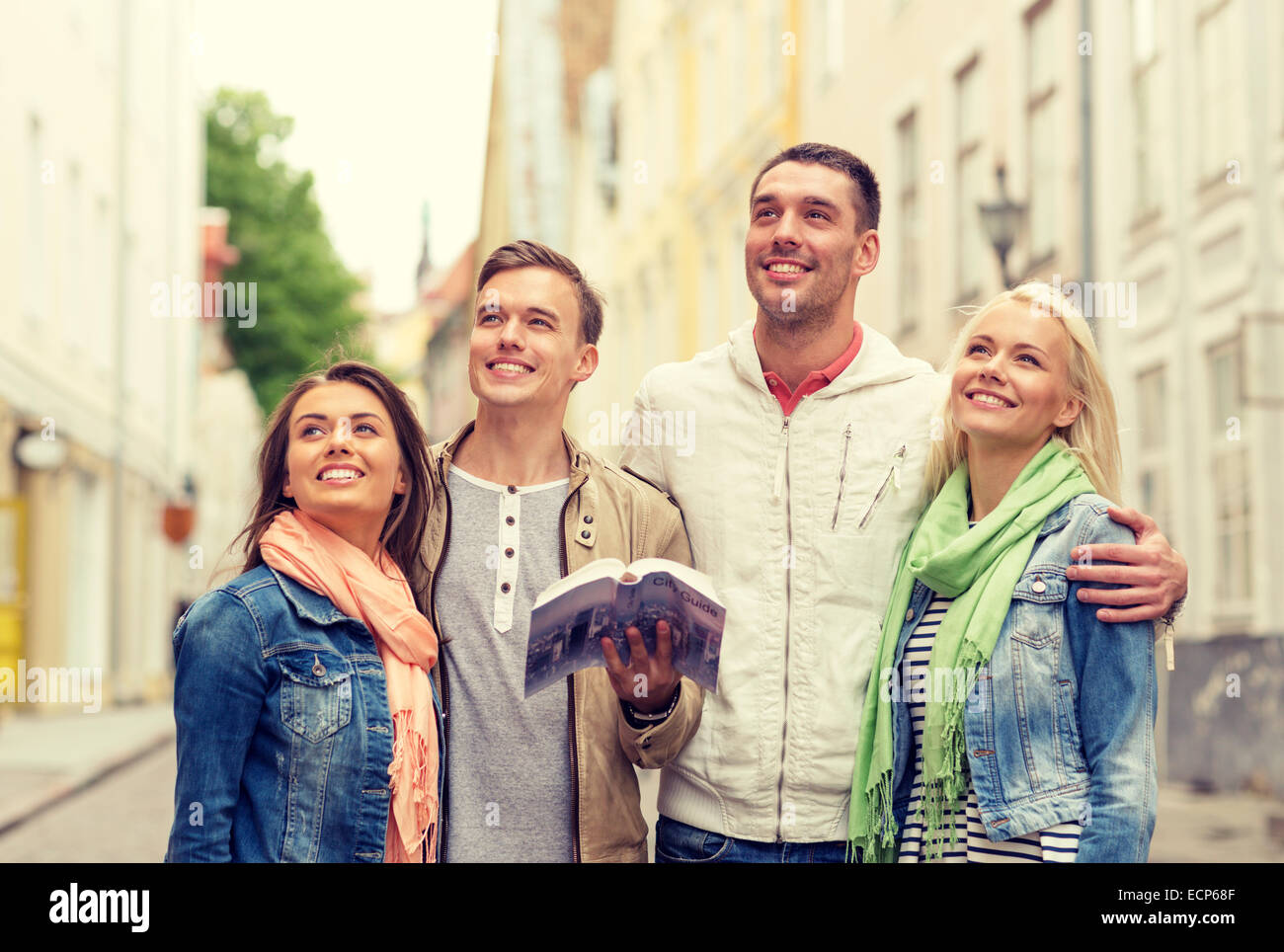 group of friends with city guide exploring town Stock Photo - Alamy